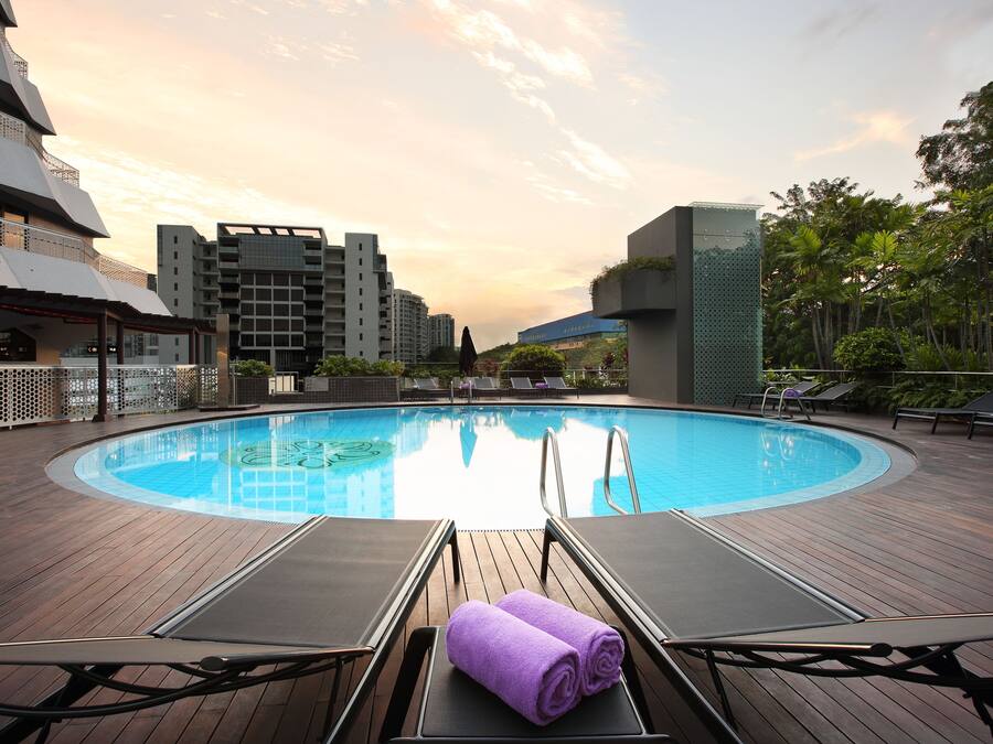 Piscina no terraço com espreguiçadeiras e uma toalha roxa.