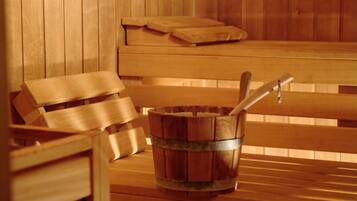 Uma sauna de madeira com bancos e um balde de madeira com um concha.