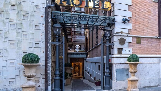 Entrada de hotel com placa, estátua e número.