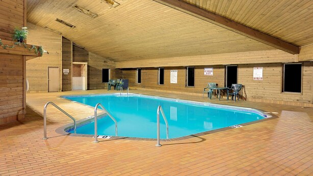 Piscina interior com interior em madeira, posto de salva-vidas e mesa de bilhar.