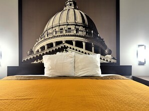 Cama com um pôster grande da cúpula e colunas de um edifício imponente.