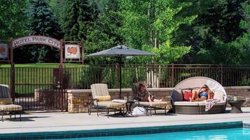 Uma área junto à piscina com espreguiçadeiras e uma placa com a inscrição 'Hotel Park City'.
