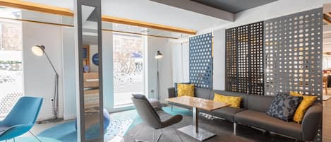 Um interior moderno com um sofá, uma mesa e uma cadeira azul.