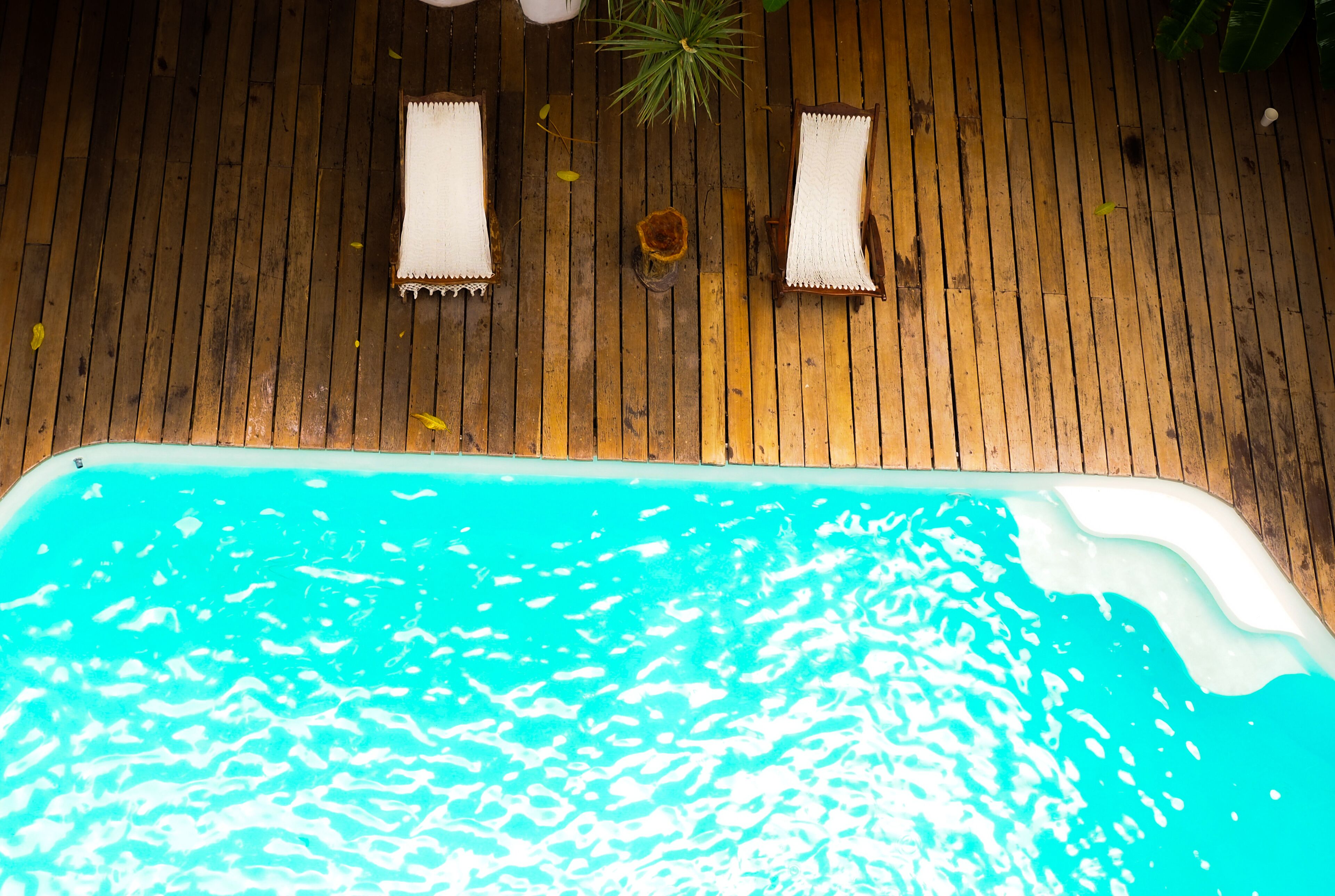 Um deck de madeira com piscina.