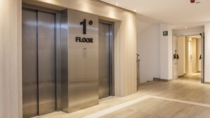 Um elevador moderno com uma placa indicando o primeiro andar.