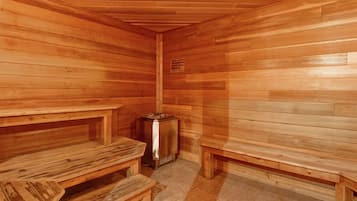 Uma sala de sauna com bancos de madeira e aquecedor central.