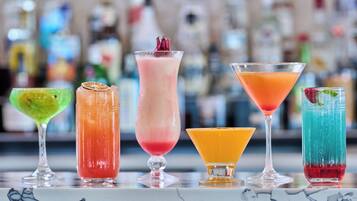 Um bar com vários cocktails coloridos em diversos copos.