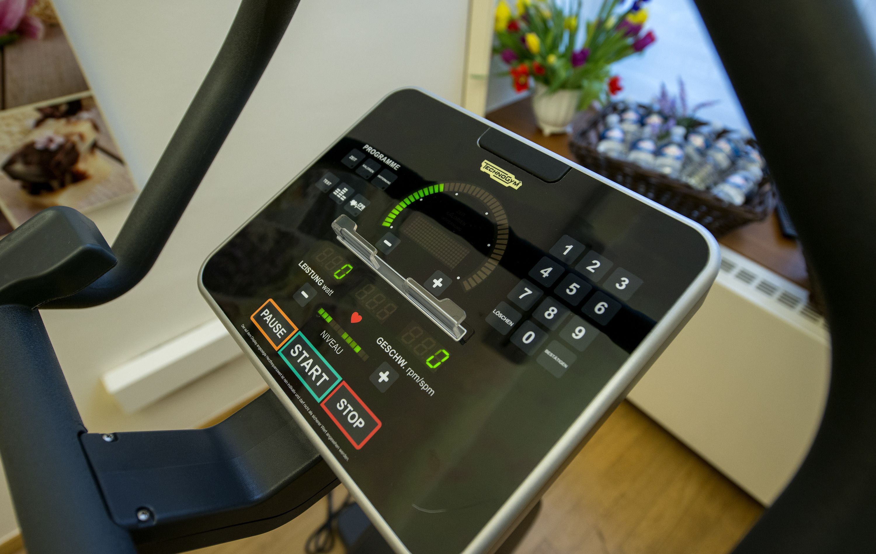 Uma bicicleta ergométrica com visor digital e painel de controle.