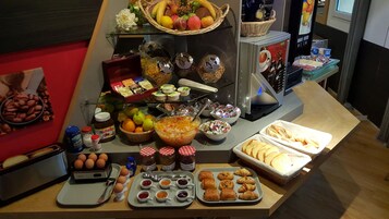 Um buffet de café da manhã com diversos alimentos e acompanhamentos.