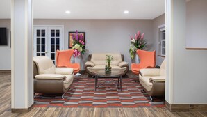 Uma sala de estar moderna com sofás bege, uma mesa de centro de vidro e cadeiras laranja.