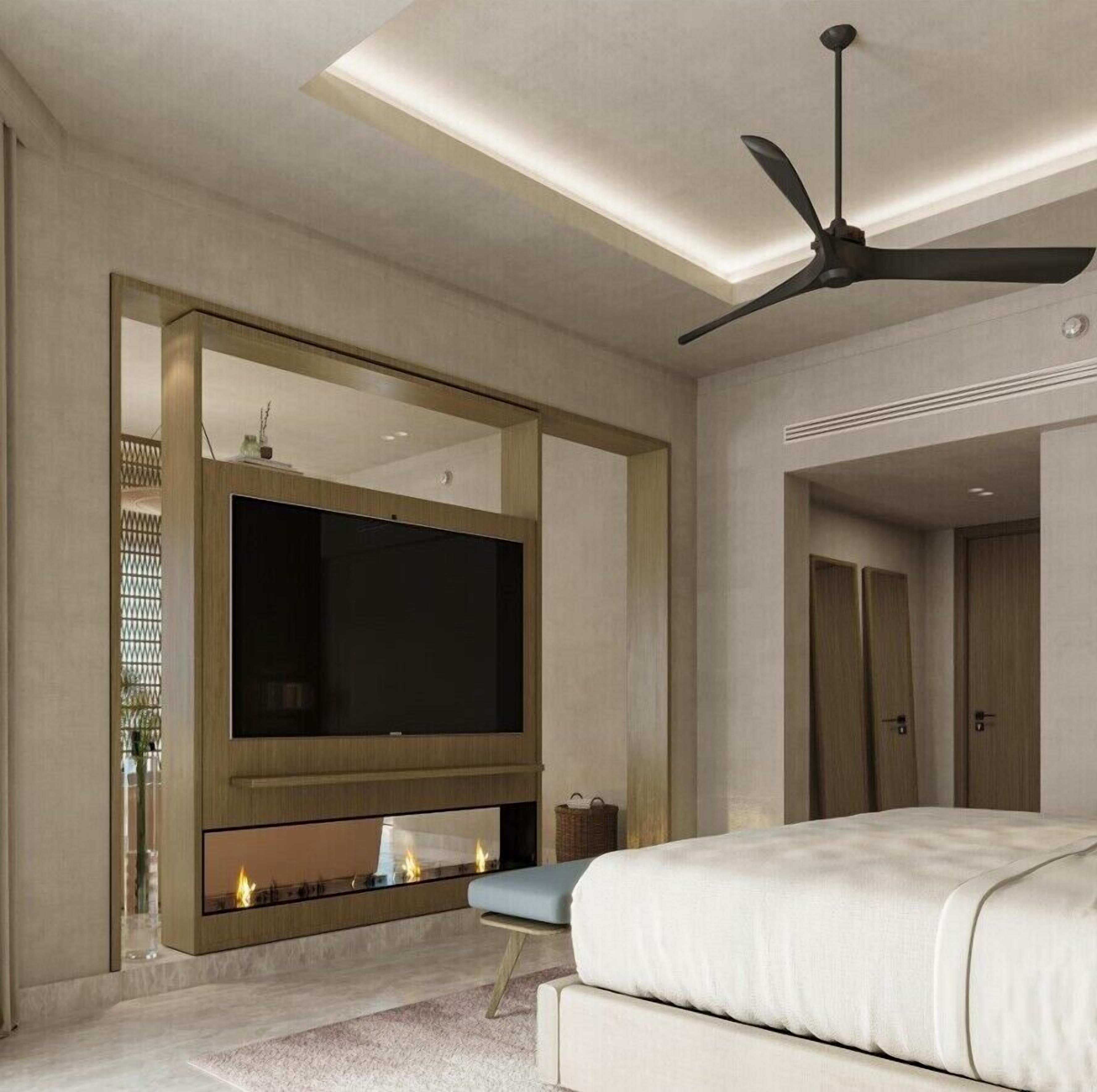 Quarto moderno com televisão grande, lareira e ventoinha no teto.