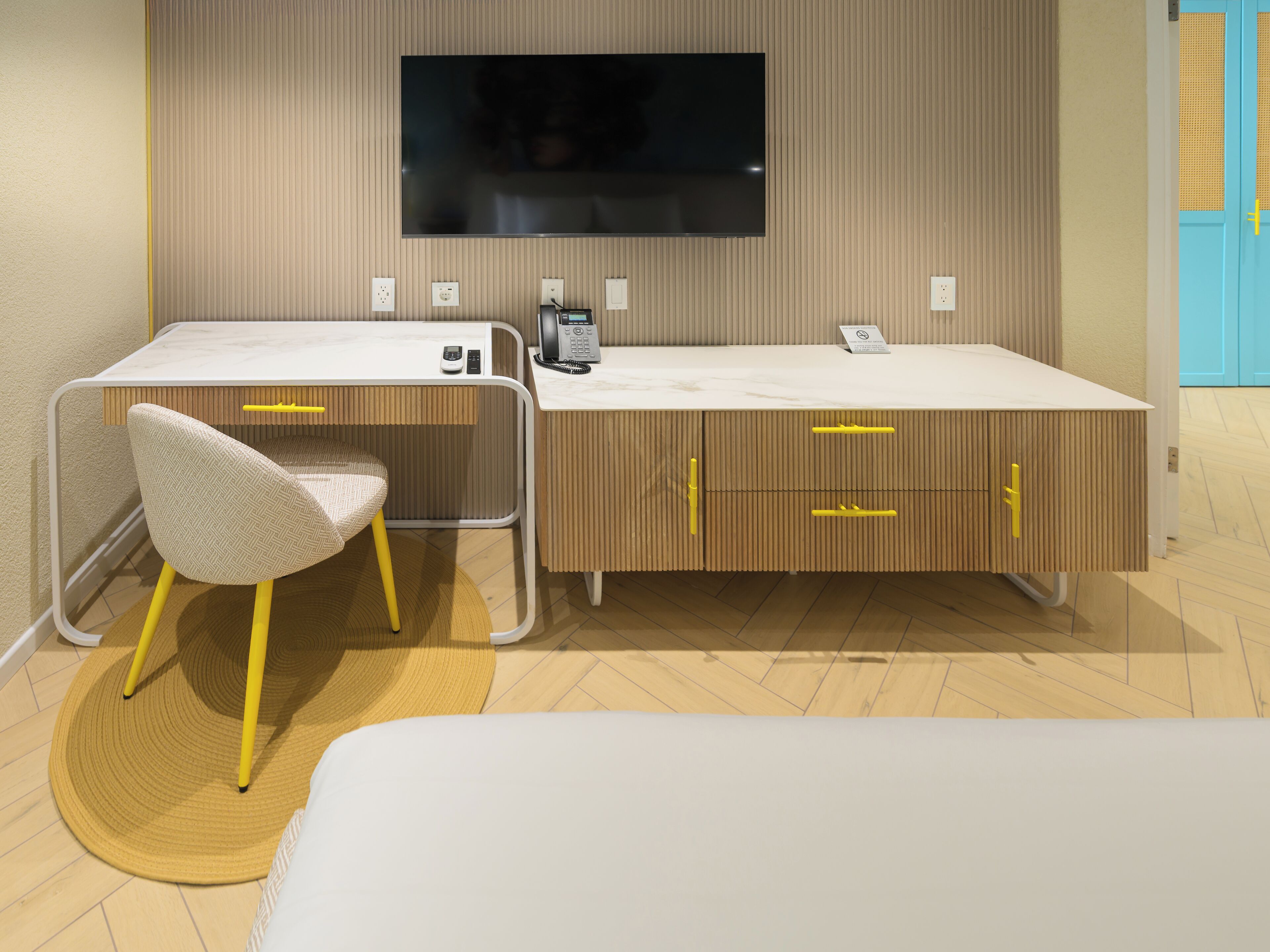 Quarto moderno com escrivaninha, cadeira e cama.
