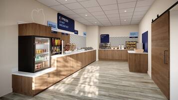 Uma área de café da manhã moderna com balcão refrigerado, seção de frutas e cereais, e mostrador de pães.
