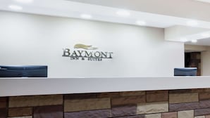Um balcão de recepção com o logotipo da Baymont Inn & Suites.