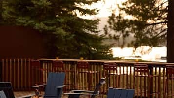Um deck externo com cadeiras Adirondack e uma lareira.
