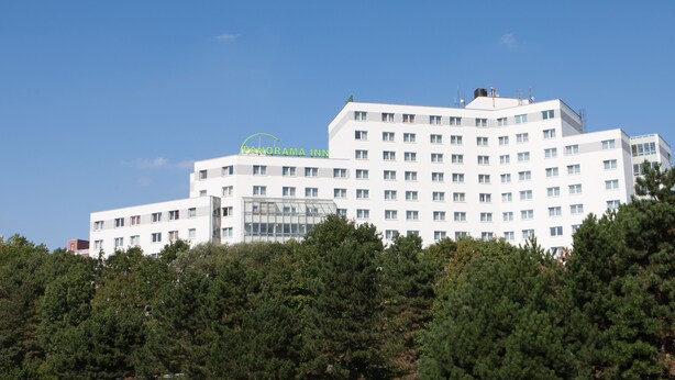 Um hotel com vários andares e design moderno, com uma placa de destaque para Panorama Inn.