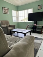 Suíte, 1 cama Queen e sofá-cama | Área de estar | TV de tela plana