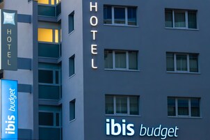 Um edifício de hotel com o nome "ibis budget" em destaque na fachada.