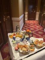 Mesa de buffet de café da manhã com diversos alimentos e bebidas.