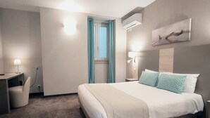 Um quarto moderno com uma cama grande, uma escrivaninha e uma cadeira.