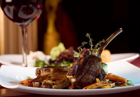 Um prato de comida com um copo de vinho tinto.