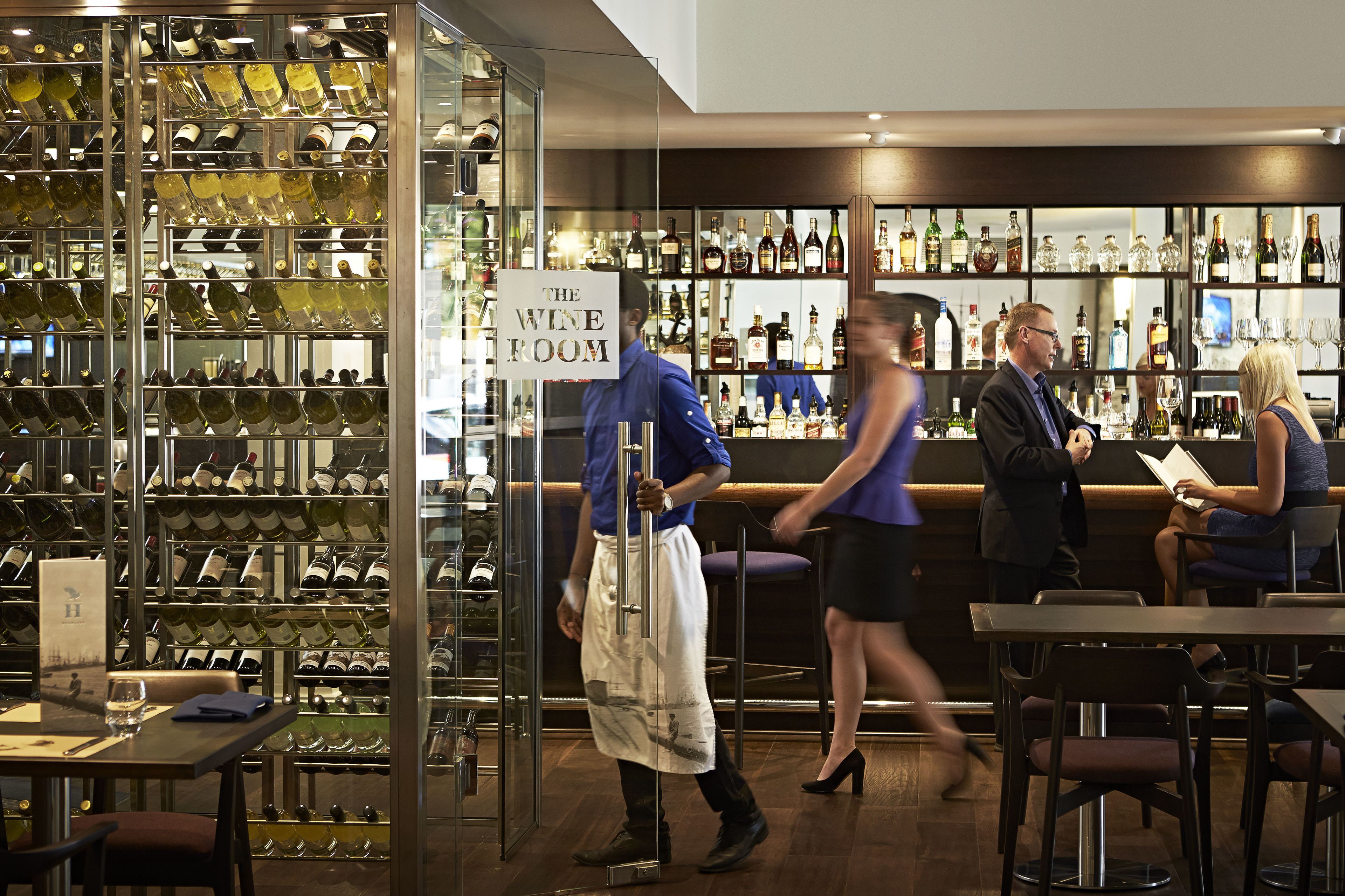 Uma adega com prateleiras cheias de garrafas de vinho e um letreiro com a inscrição 'The Wine Room'.