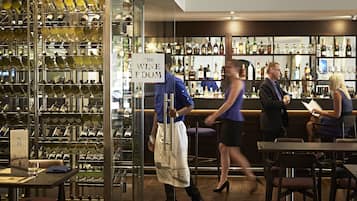 Uma adega com prateleiras cheias de garrafas de vinho e um letreiro com a inscrição 'The Wine Room'.
