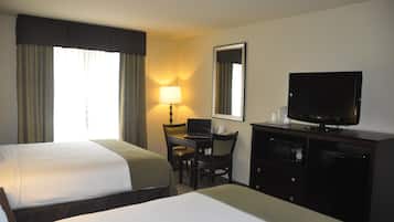 Quarto de hotel com duas camas, uma escrivaninha com cadeira, televisão e micro-ondas.