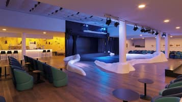 Uma área de estar moderna com assentos, bar e palco.