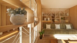 Uma sala de estar moderna com escada de madeira, um sofá verde e um vaso decorativo com flores.