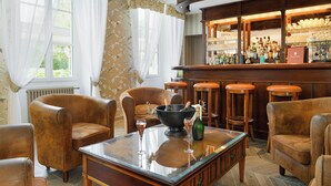 Uma área de bar com cadeiras de couro, balcão e uma grande tigela com uma garrafa.
