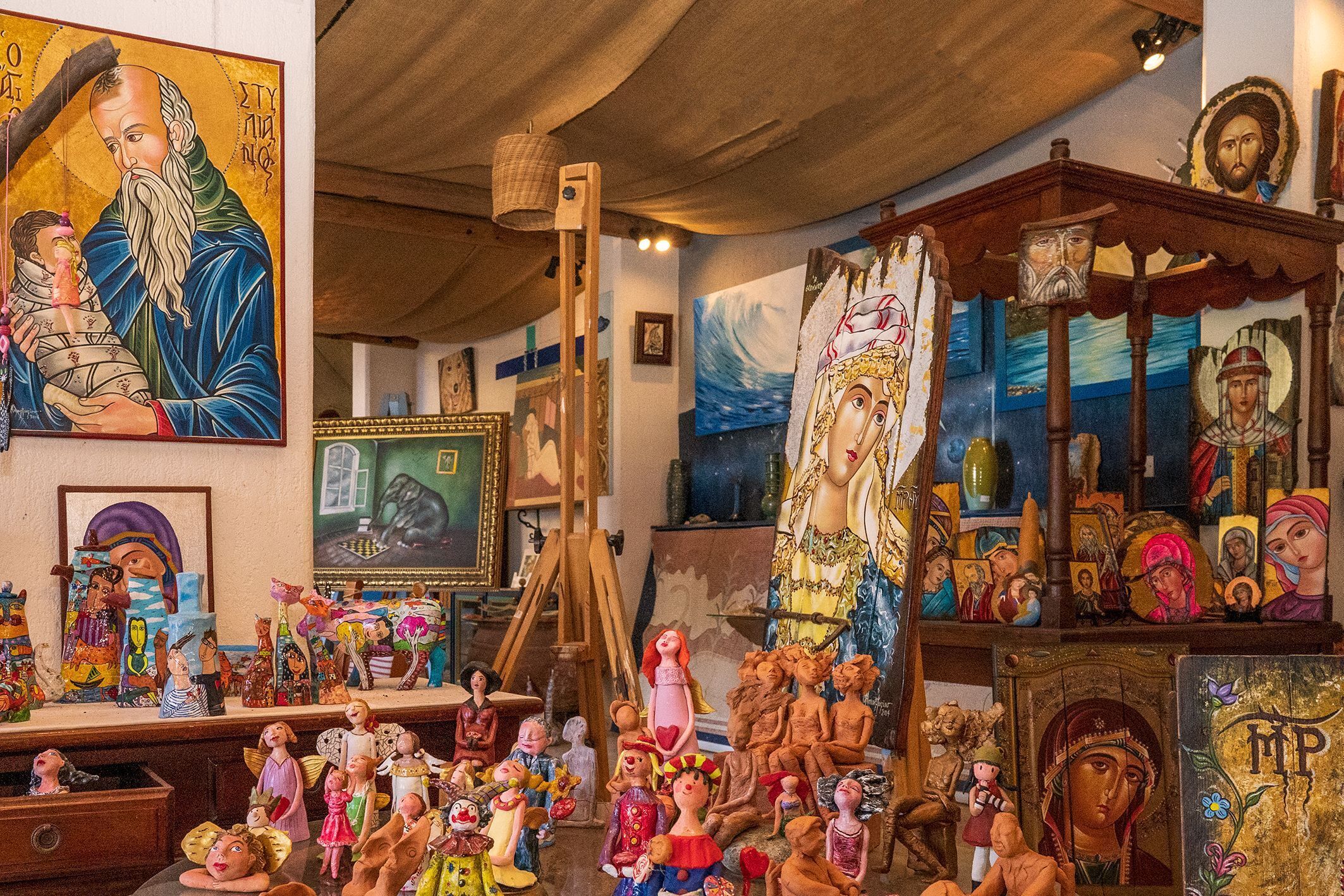 Quarto com ícones religiosos, pinturas e diversas figuras.