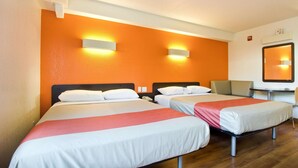 Quarto de hotel com duas camas, uma escrivaninha e uma cadeira.