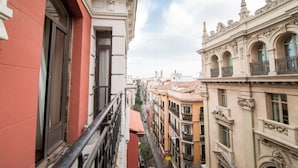 Uma rua estreita com edifícios com fachadas e varandas ornamentadas.