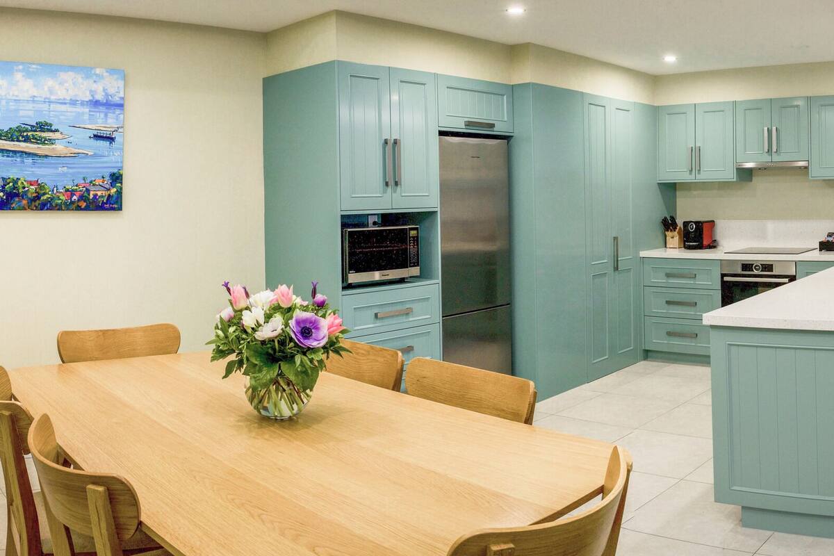 Um apartamento moderno com cozinha, sala de jantar, sala de estar e televisão.
