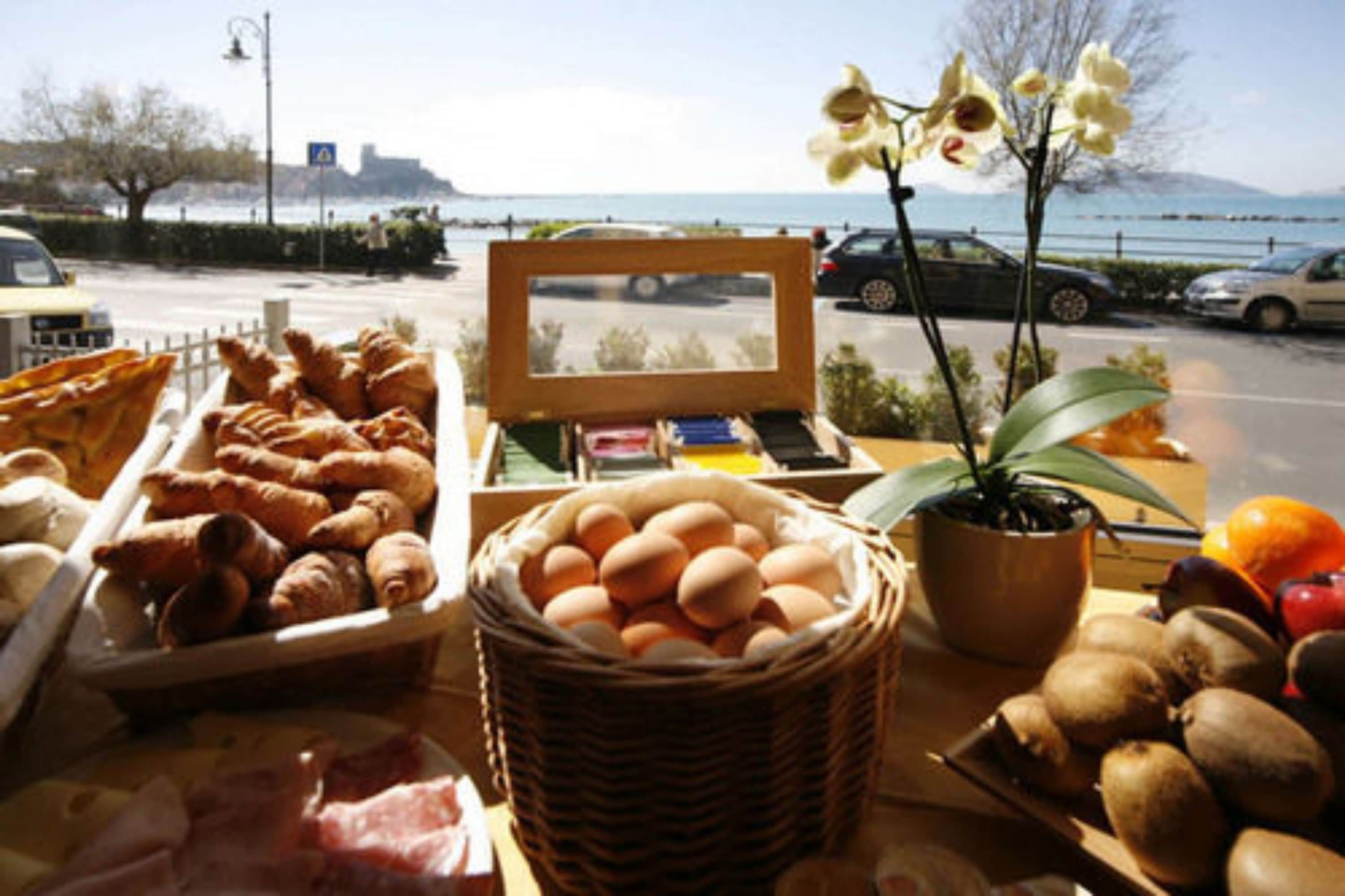 Buffet de café da manhã com pães, ovos e frutas.