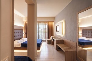 Quarto de hotel moderno com duas camas, uma escrivaninha e um espelho grande.
