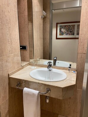 Um secador de cabelo, toalhas fornecidas, sabão, champô 