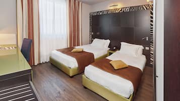 Quarto de hotel com duas camas, uma escrivaninha e uma cadeira.