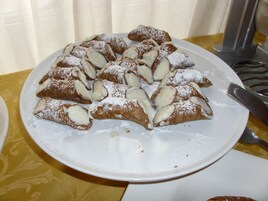 Um prato de cannoli com açúcar em pó sobre uma mesa.