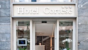 Exterior do Hotel Cortese com fachada moderna, janelas amplas e escadaria visível que leva à entrada.