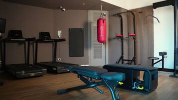 Uma academia com esteiras, saco de pancadas e equipamentos de ginástica.