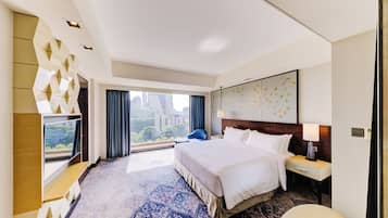 Quarto de hotel com uma cama grande, escrivaninha, cadeira, TV e vista para a cidade.