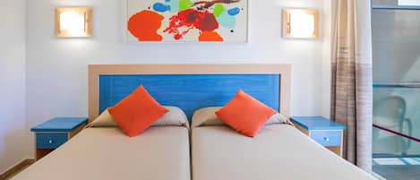 Uma cama de casal com duas almofadas laranjas, um painel de cabeceira azul e um quadro abstrato emoldurado acima.