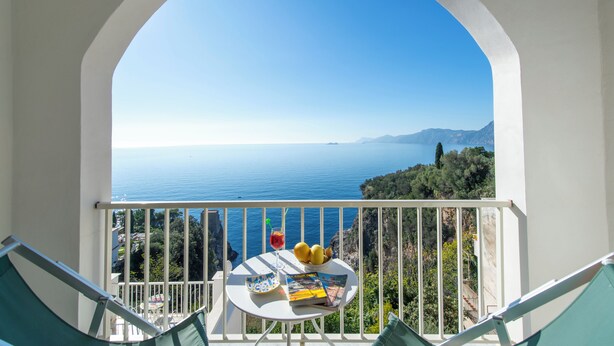 Uma varanda com vista para o mar e montanhas.