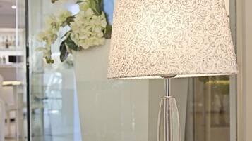 Uma luminária de mesa moderna com cúpula estampada sobre uma mesa em um ambiente bem iluminado.