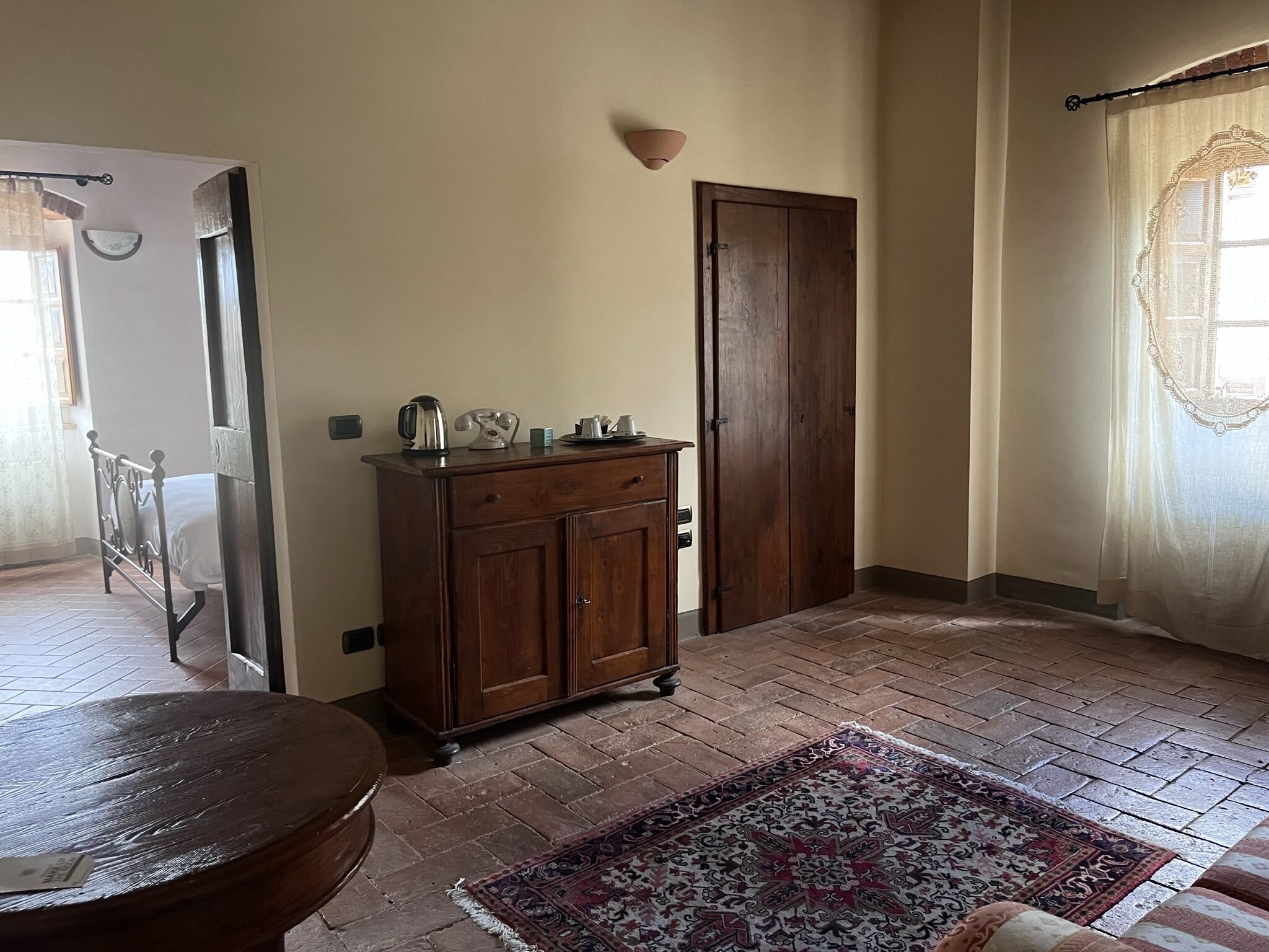 Um quarto com um armário de madeira, um tapete estampado e uma porta.