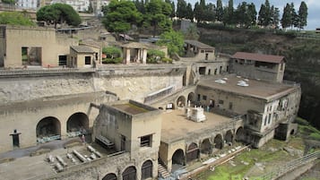 Um edifício histórico com vários níveis, apresentando varandas em arco e um pátio.
