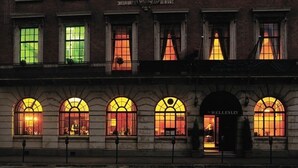 Um edifício com janelas em arco e um café chamado 'Wellesley' no andar térreo.
