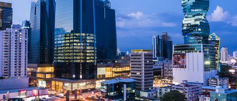 Paisagem urbana com arranha-céus modernos, incluindo um edifício com design retorcido e um arranha-céu alto e retangular.